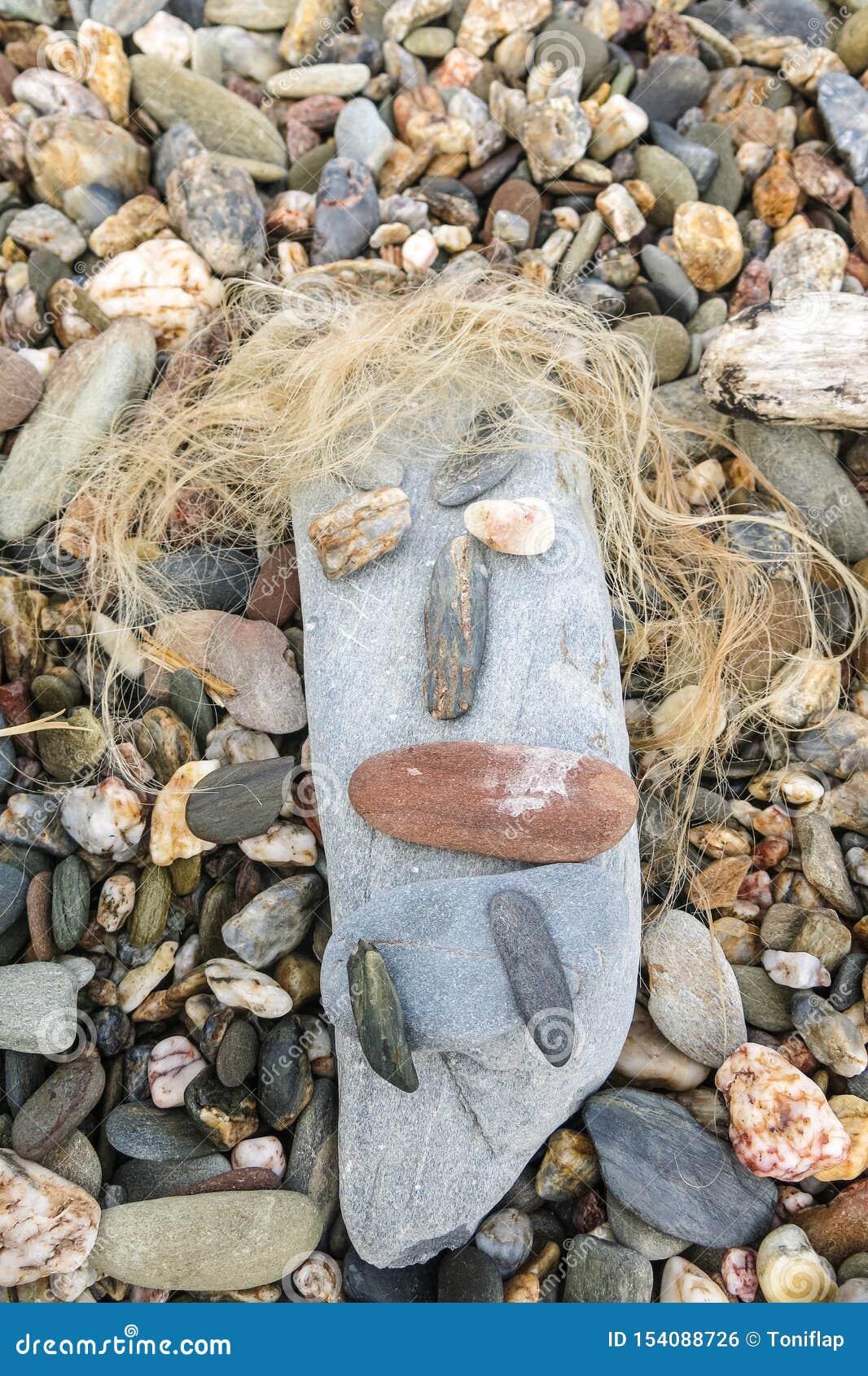Simpatic Face Created on a Beach with Small Stones and Dried Algae ...
