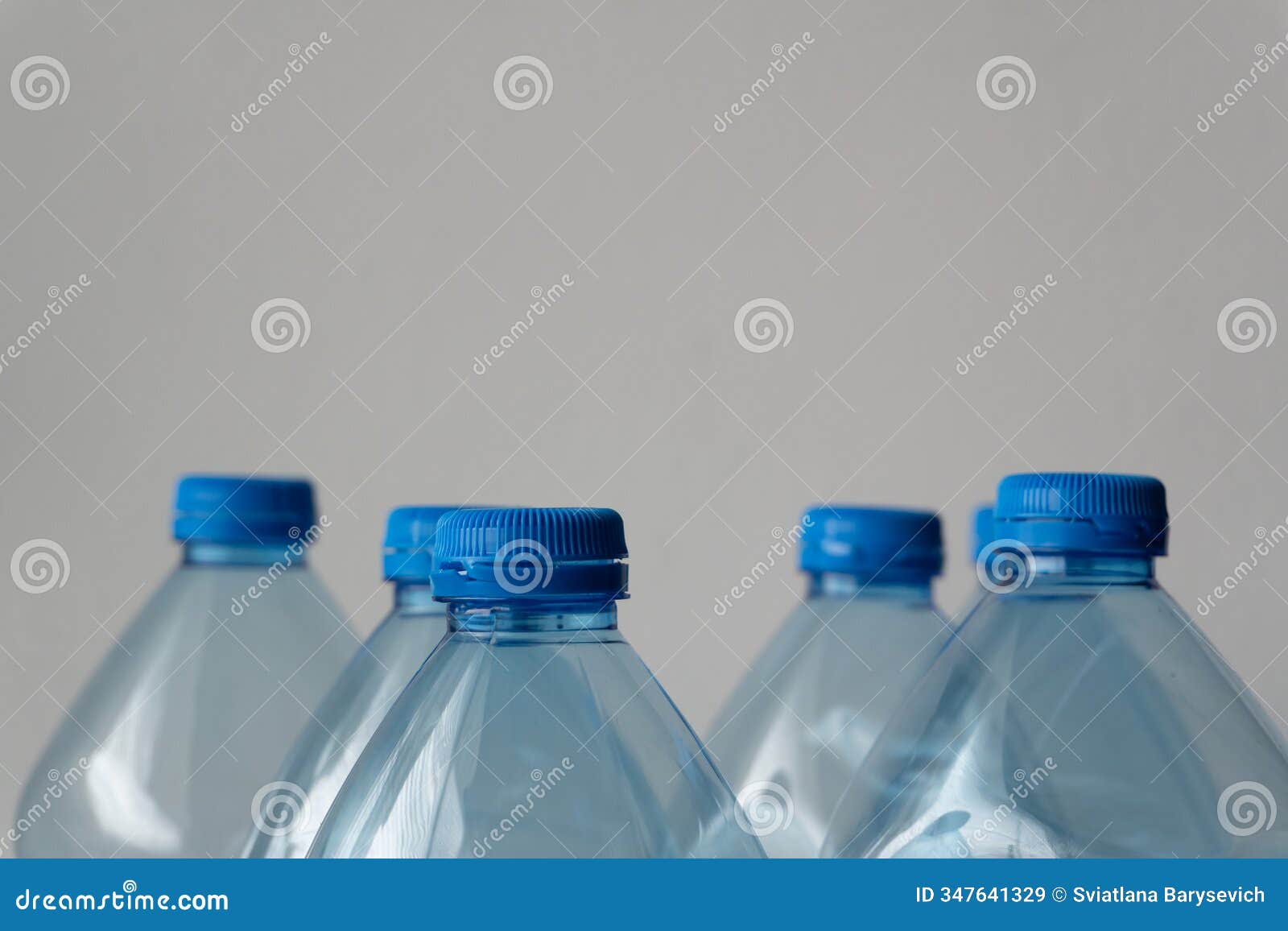 Several Plastic Bottles with Blue Caps are Grouped Together Against a ...