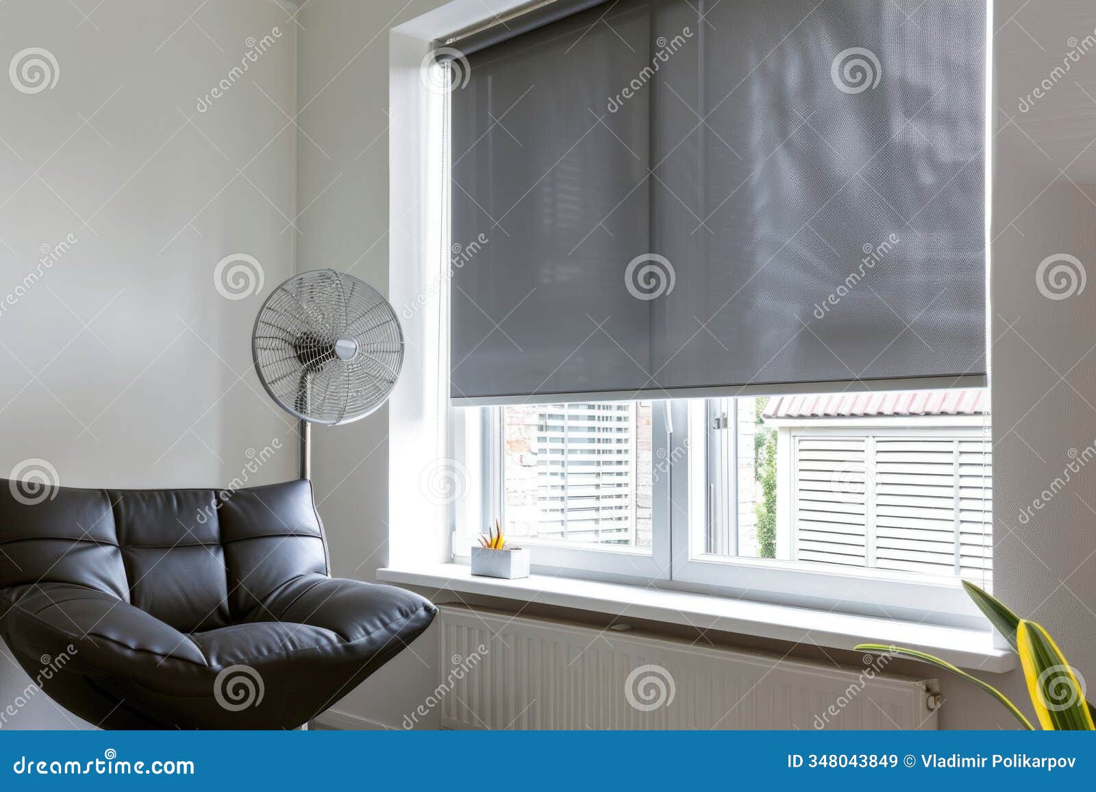 A Simple Scene of a Black Chair Facing a Window with a Fan Installed ...