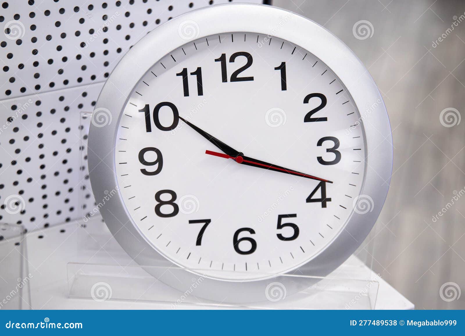 A Simple White Round Wall Clock Stands and is Sold on a Shelf in a ...