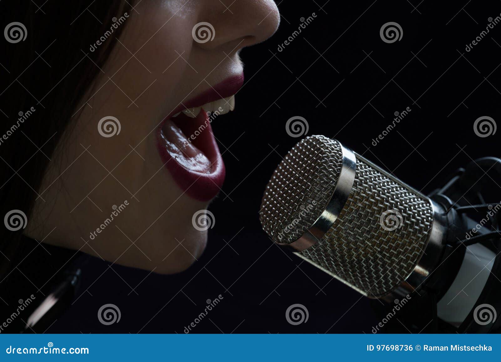 Singer in Front of a Microphone. Isolated on a Dark Background Stock ...
