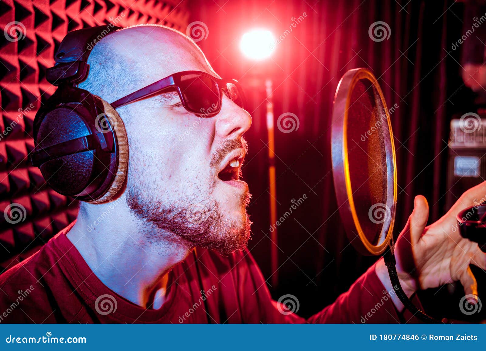 The Singer Sings with a Microphone in the Recording Studio. Stock Photo ...