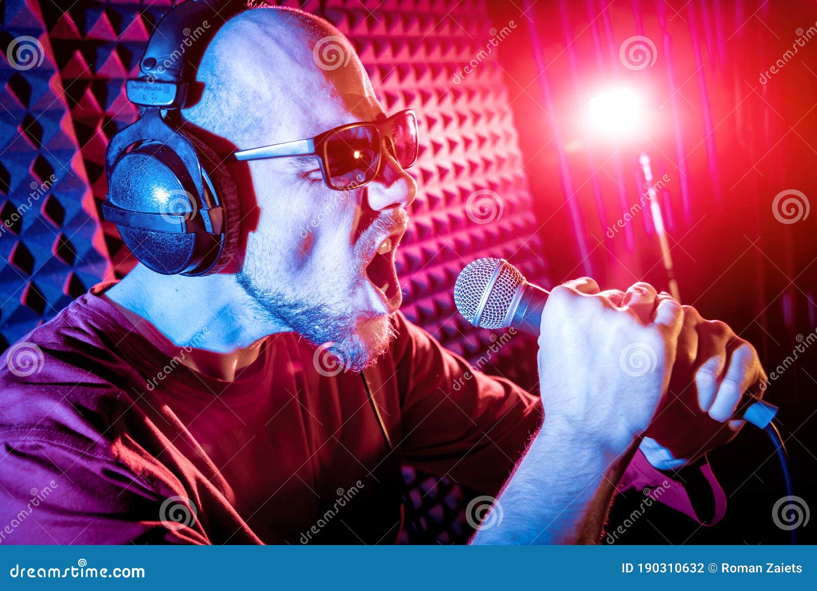 The Singer Sings with a Microphone in the Recording Studio. Stock Photo ...