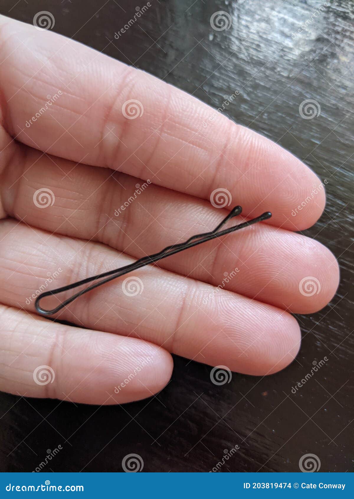 Single bobby pin in hand stock photo. Image of single - 203819474