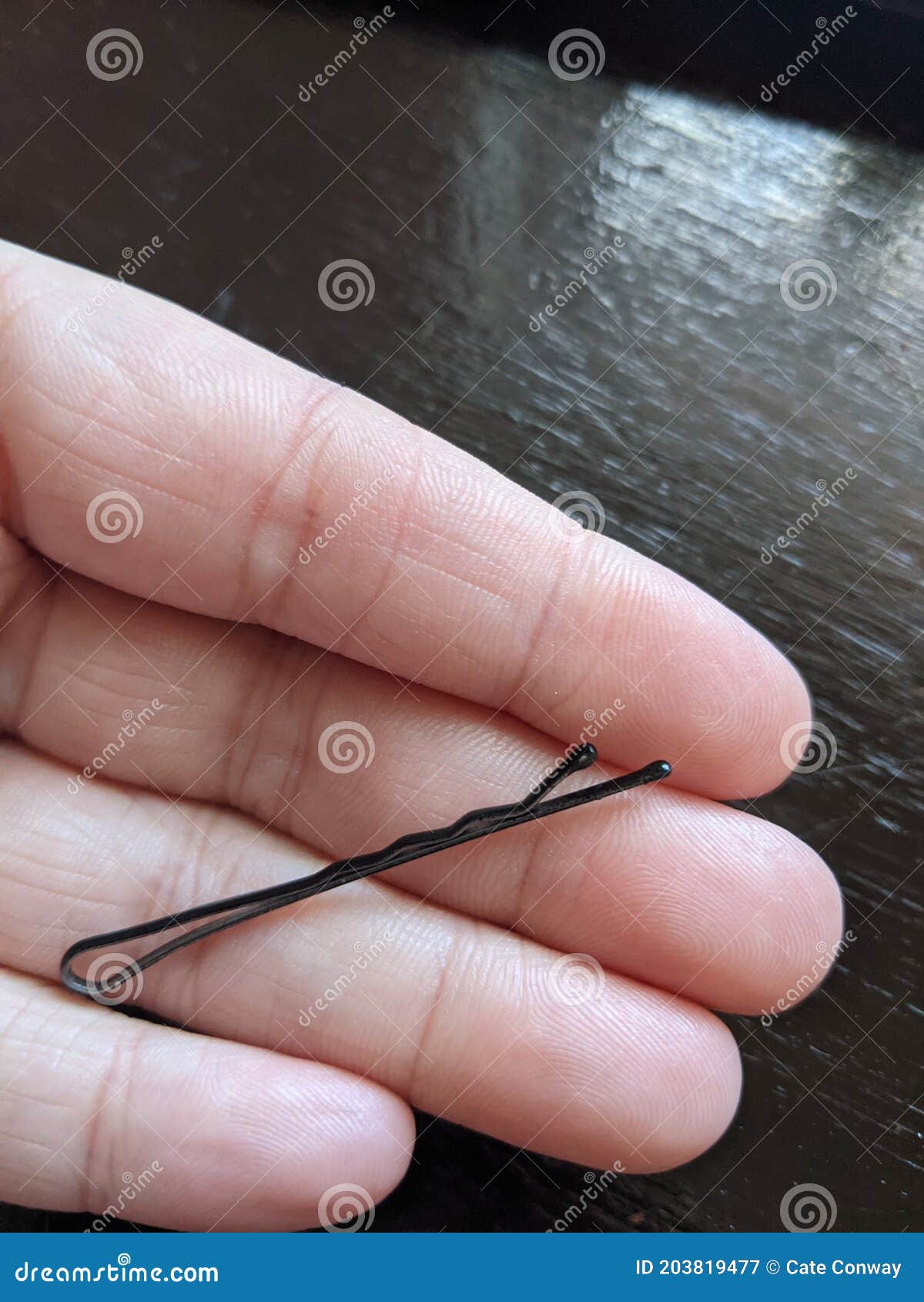 Single bobby pin in hand stock image. Image of care - 203819477