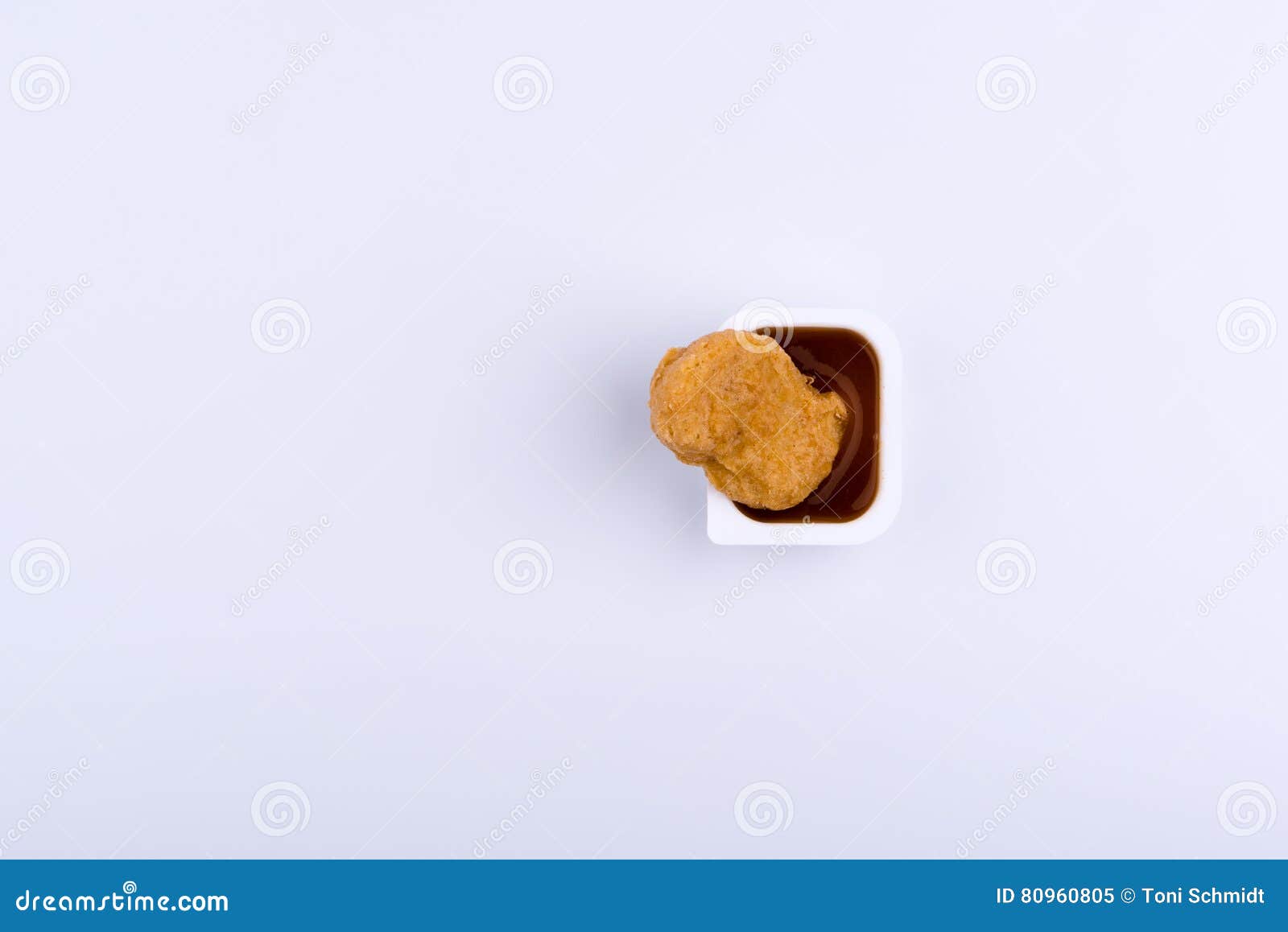 Single Chicken Nugget Standing In Red Dip Sauce In Plastic Container ...