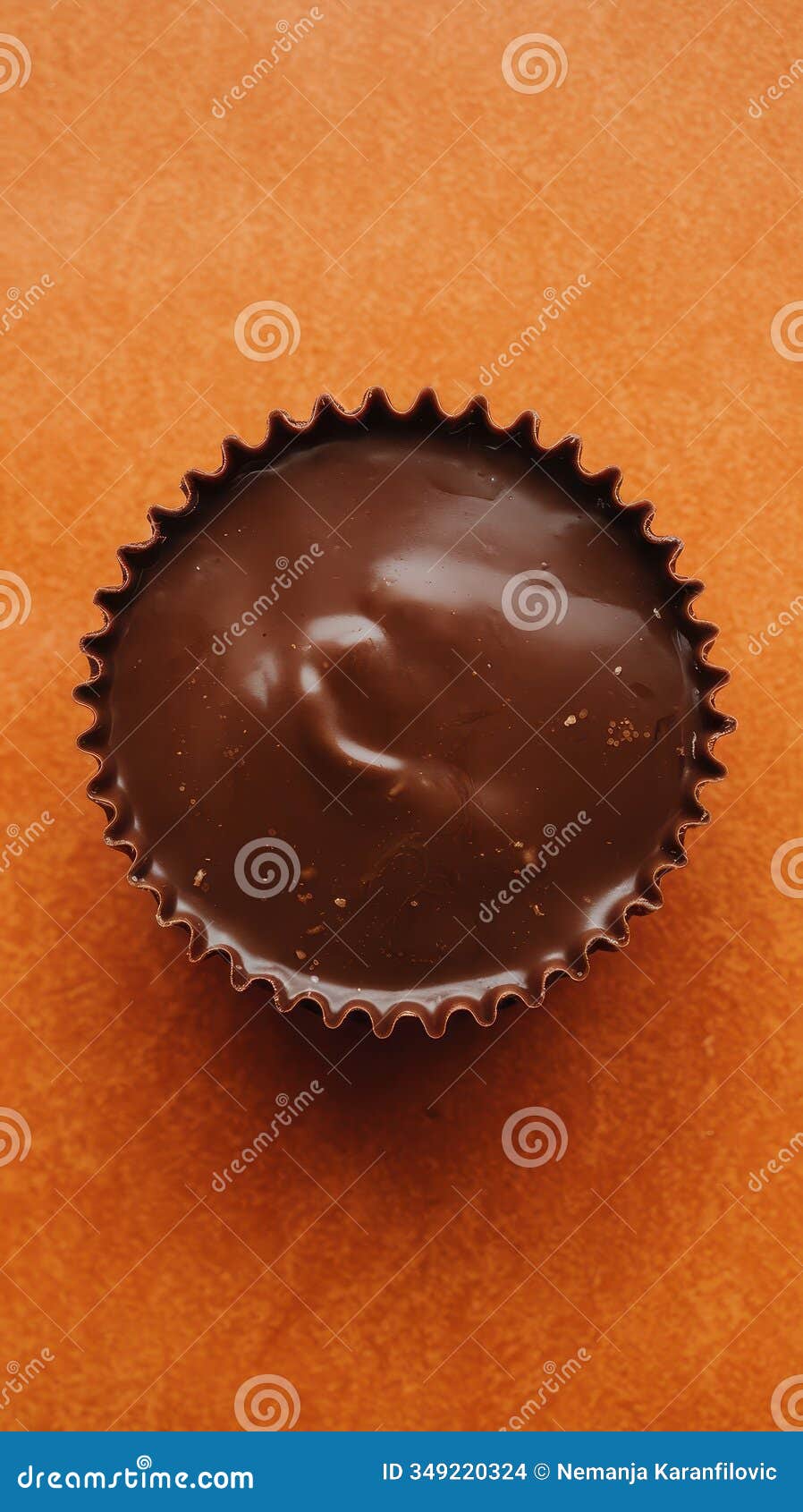 Single Chocolate Candy Partially Wrapped on Orange Background Stock ...