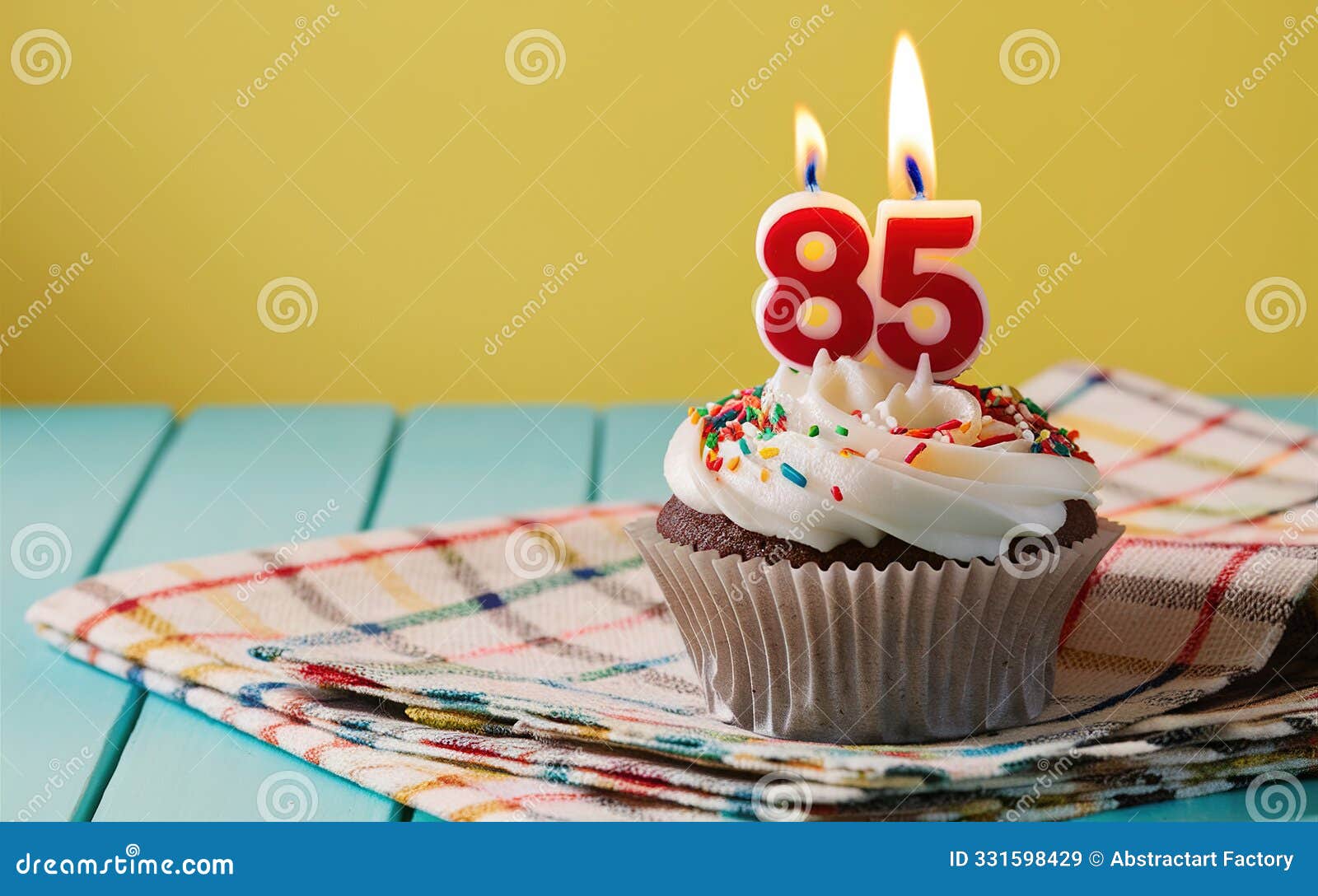 A Single Cupcake Adorned with Two Lit Candles, Signifying an 85th ...