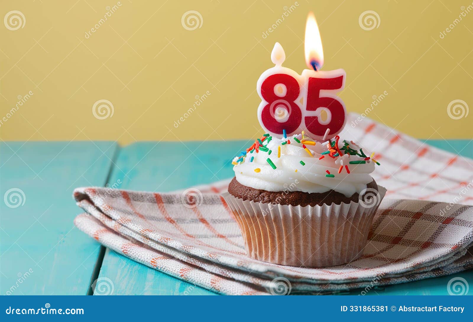 A Single Cupcake Adorned with Two Lit Candles, Signifying an 85th ...