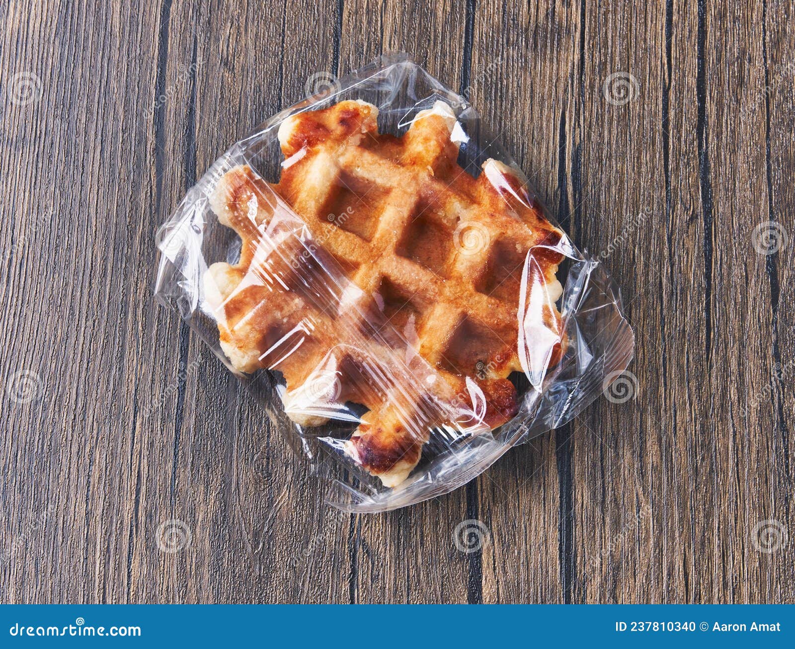 Single Delicious Waffle Wrapped on Plastic Bag on Wooden Surface Stock ...