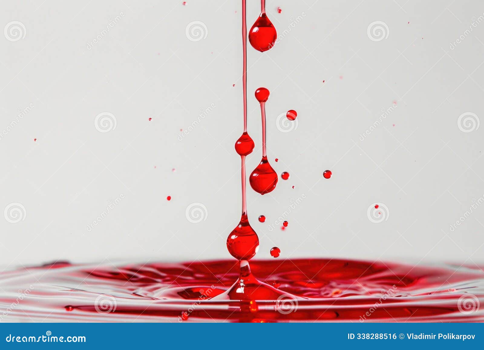 A Single Drop of Red Liquid Falls from Above into the Calm Surface of ...
