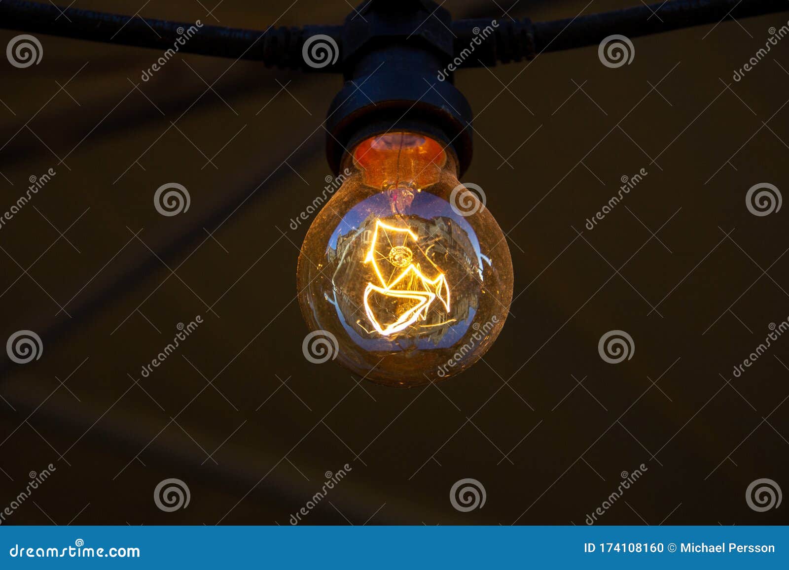 A Single Electric Light Bulb Lit Hanging from the Ceiling Stock Photo ...