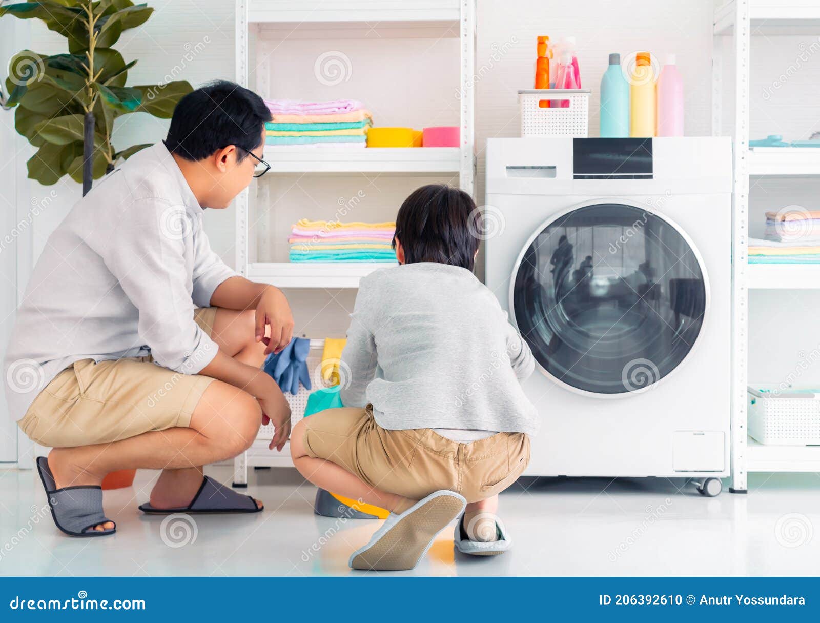 Father with His Son Helping with Laundry Washing Machine Loading. Back ...