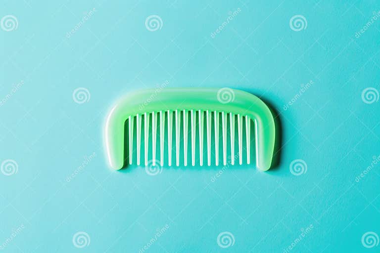 A Single Green Comb Sits on Top of a Bright Blue Surface, Ready for Use ...