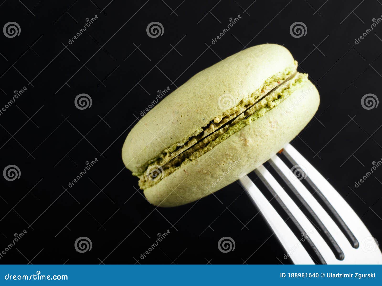 Single Green Macaron or Macaroon Cake on a Fork on Black Background ...