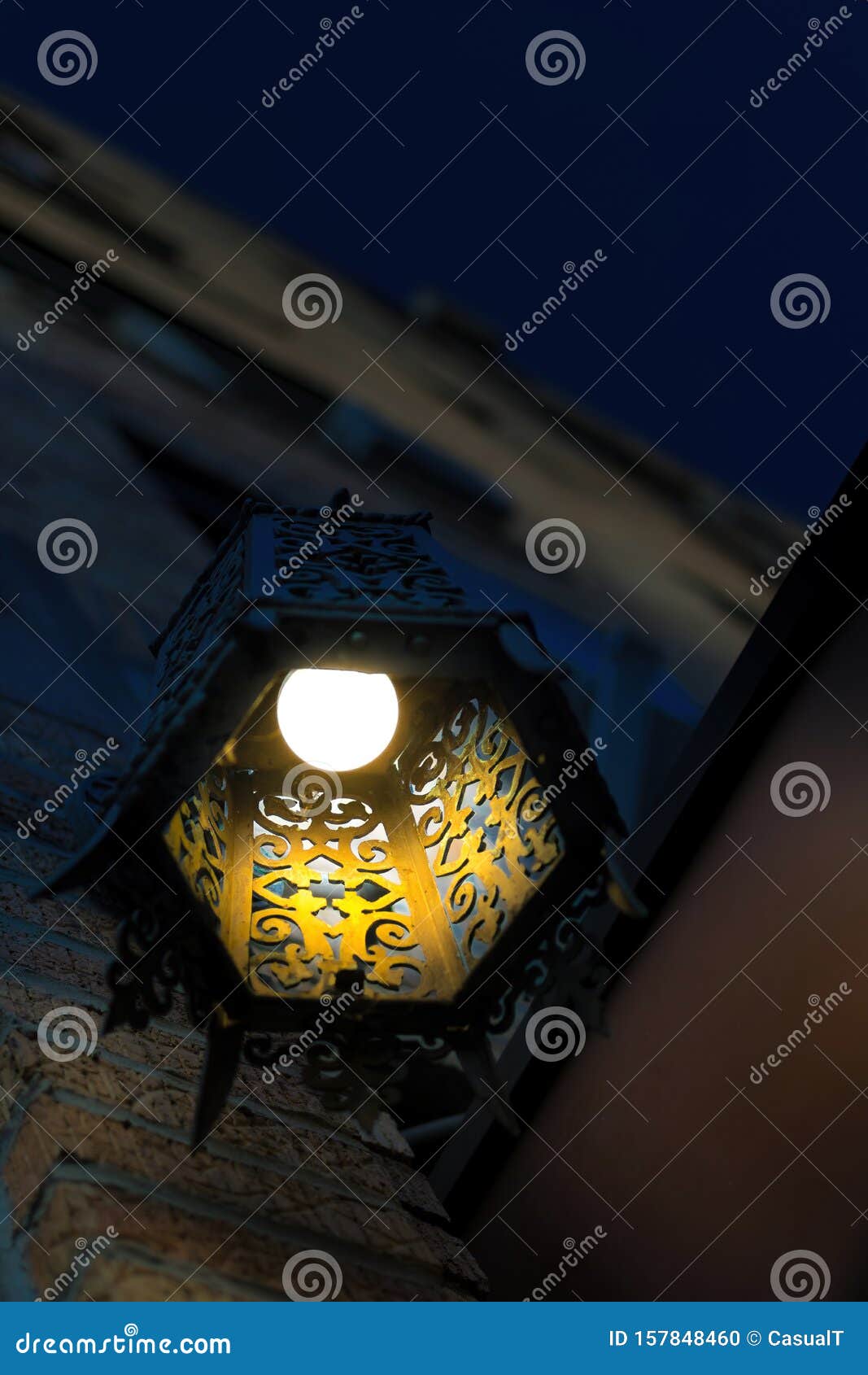 A Single Lantern and Glowing Lightbulb, Mounted on a Building Wall at ...