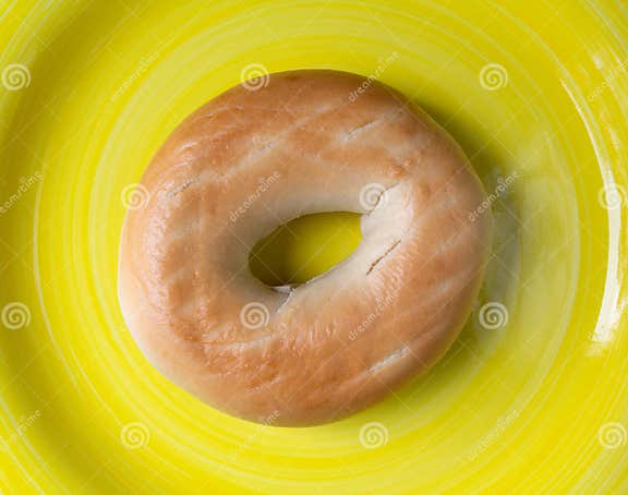 Single Plain Bagel on a Yellow Plate Top View Stock Photo - Image of ...