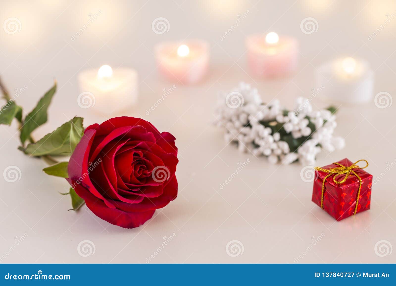 Single Red Rose, Gift Box, and Candles on White Table Stock Image ...