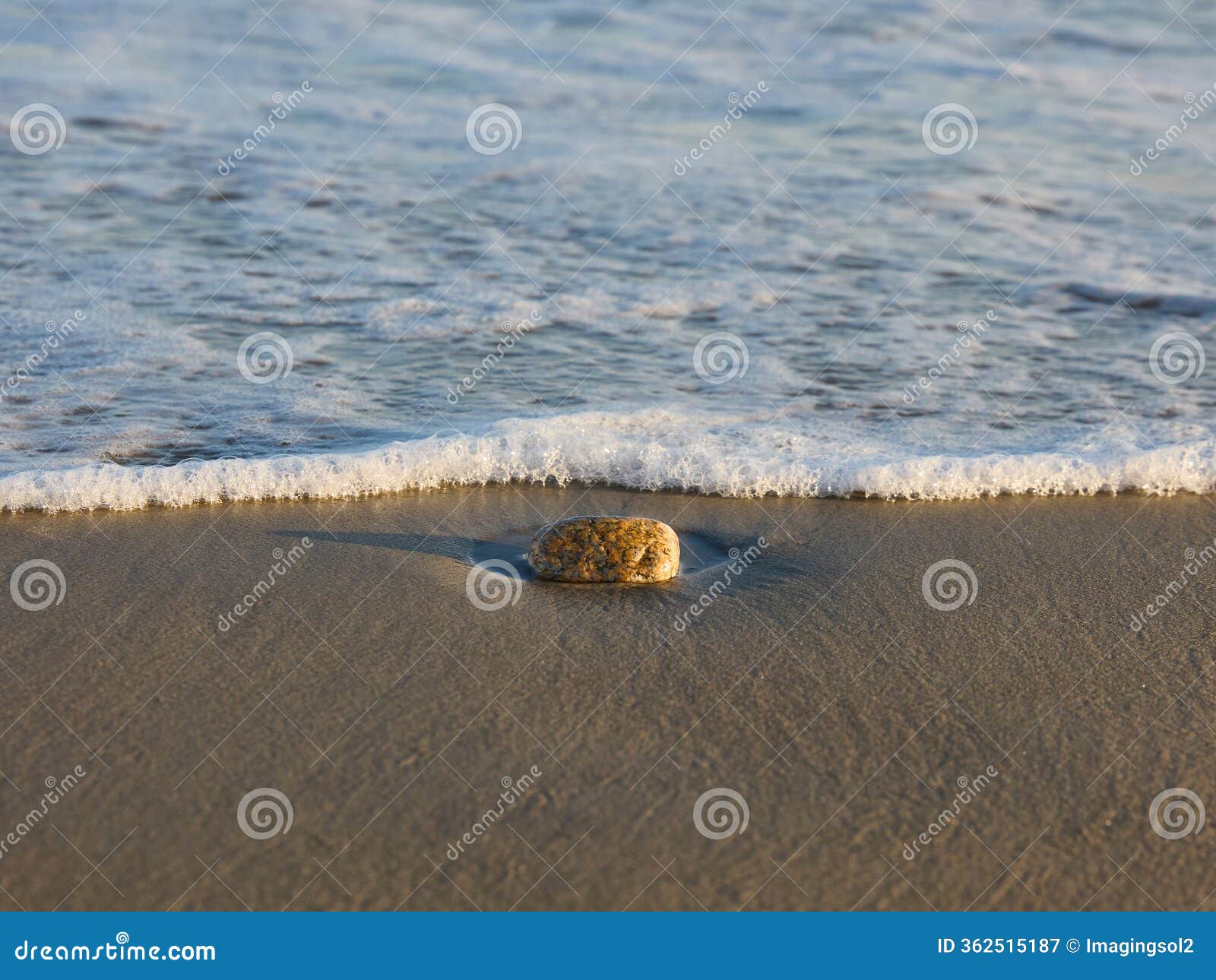 Single Rock in the Sand with Wave Approaching. Stock Image - Image of ...