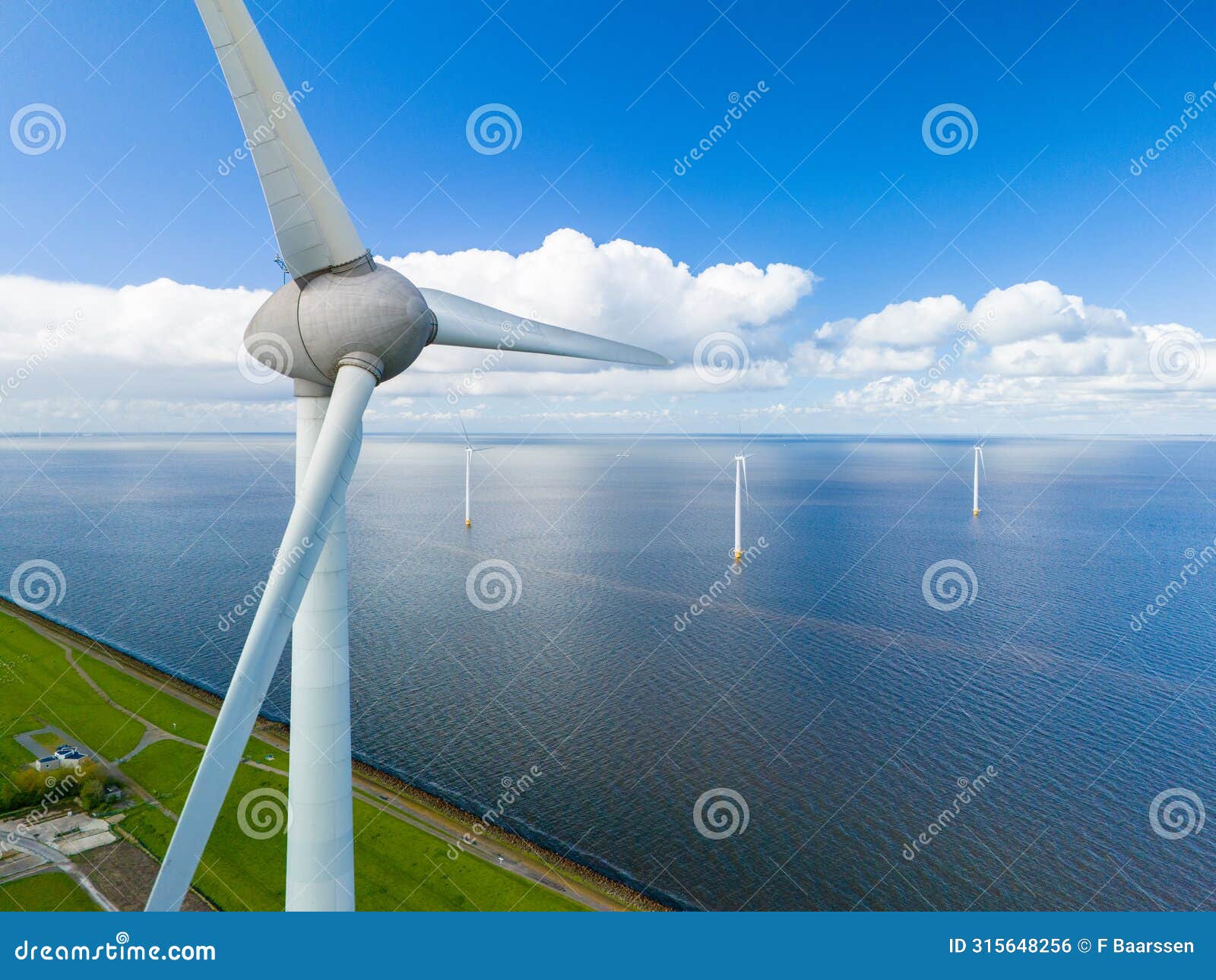 A Single Wind Turbine Towers Over The Ocean, Its Blades Spinning ... A Single Wind Turbine Towers Over The Ocean, Its Blades Spinning ...