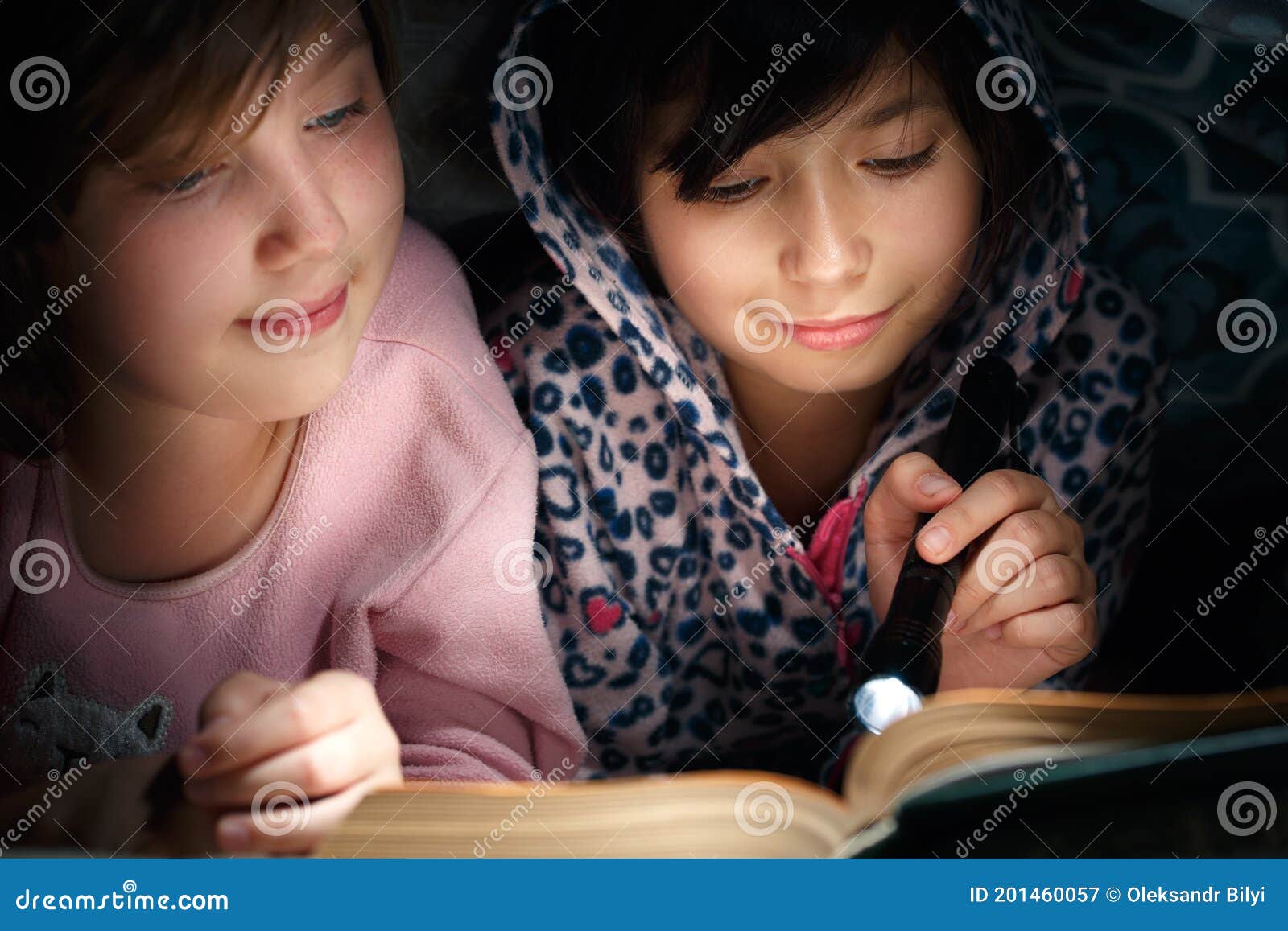 Sisters Reading Book Under Covers with Flashlight Stock Image - Image ...