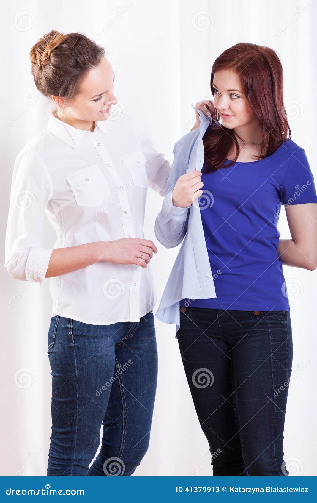 Sisters trying on shirt stock image. Image of standing - 41379913