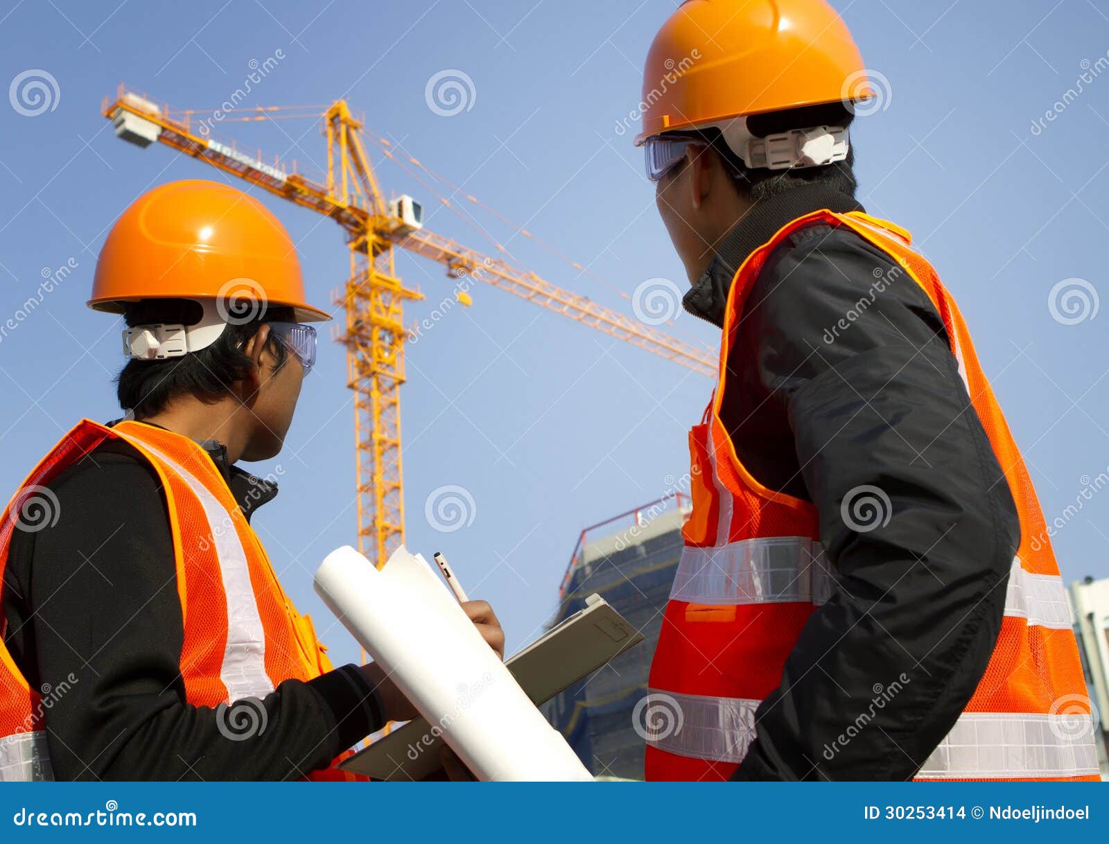 Construction Workers with Crane in Background Stock Photo - Image of ...