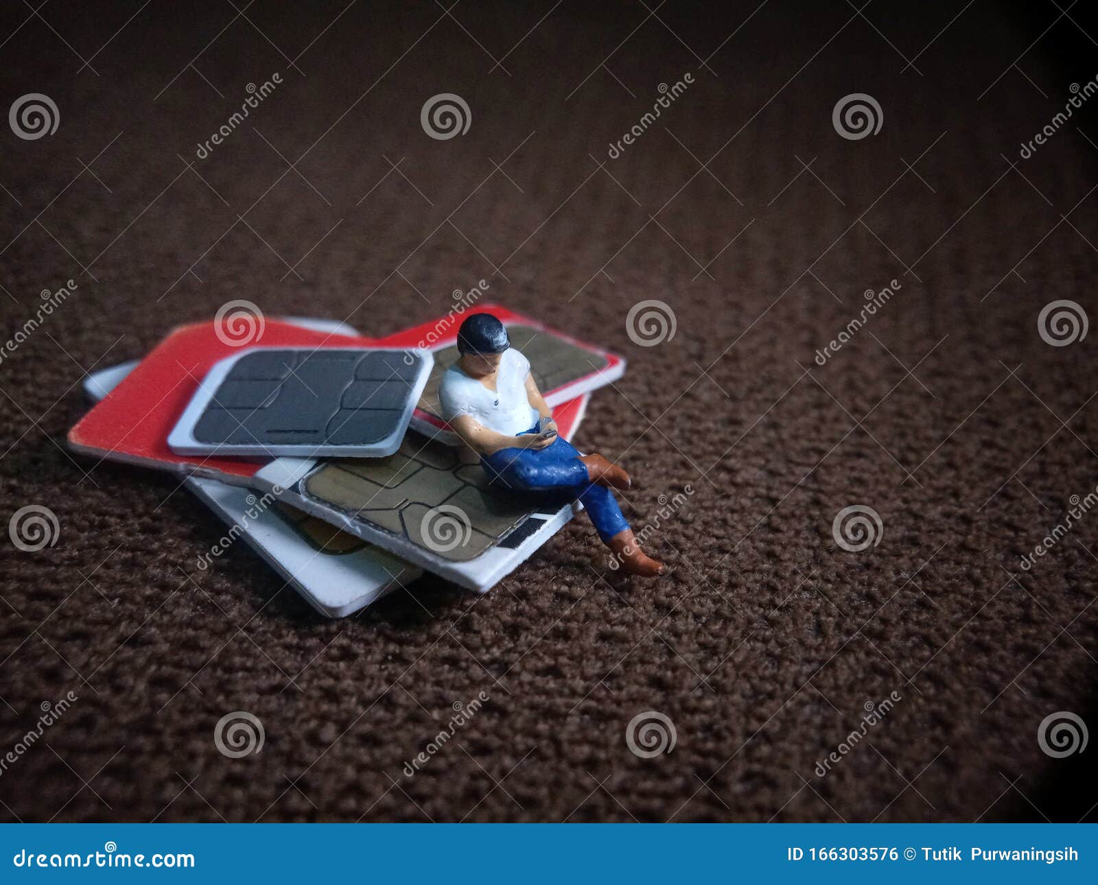 Sitting Mini Figure Man Toy Holding Smartphone at SIM Card ...