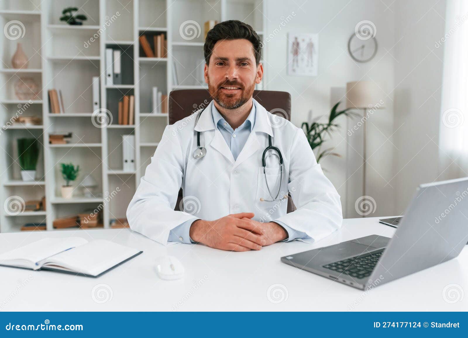 Sitting by a Table. Doctor in Formal Clothes is Working in the Cabinet ...