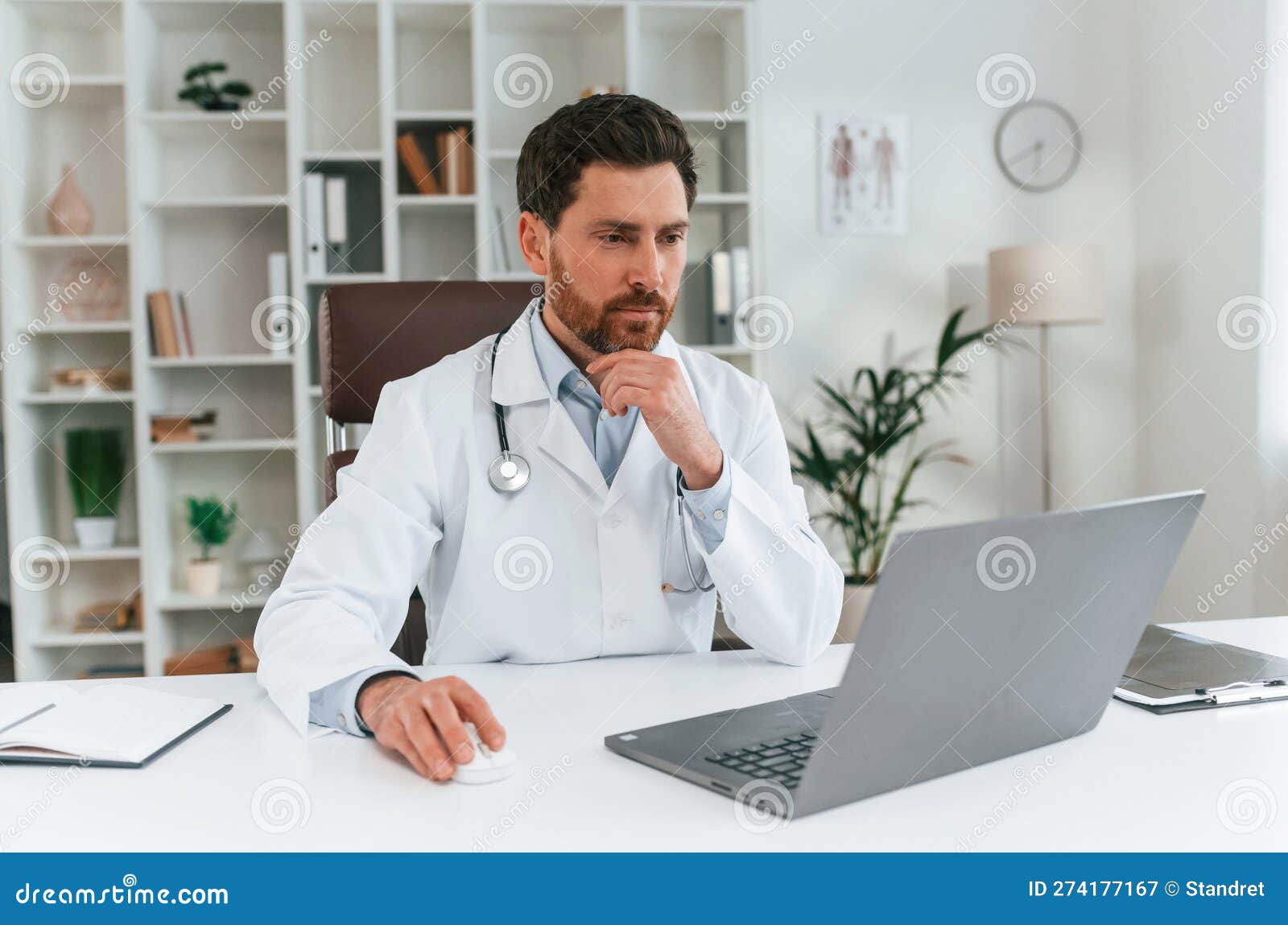 Sitting by a Table. Doctor in Formal Clothes is Working in the Cabinet ...