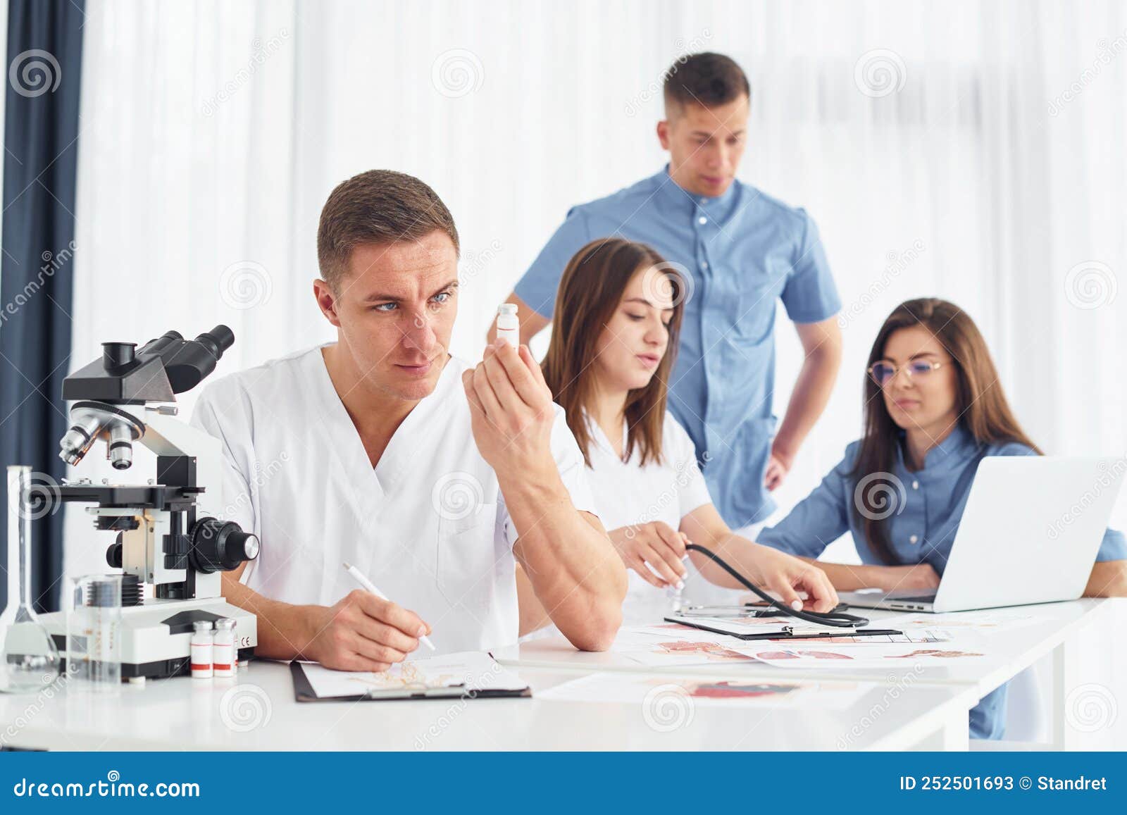 Sitting by the Table. Group of Young Doctors is Working Together in the ...