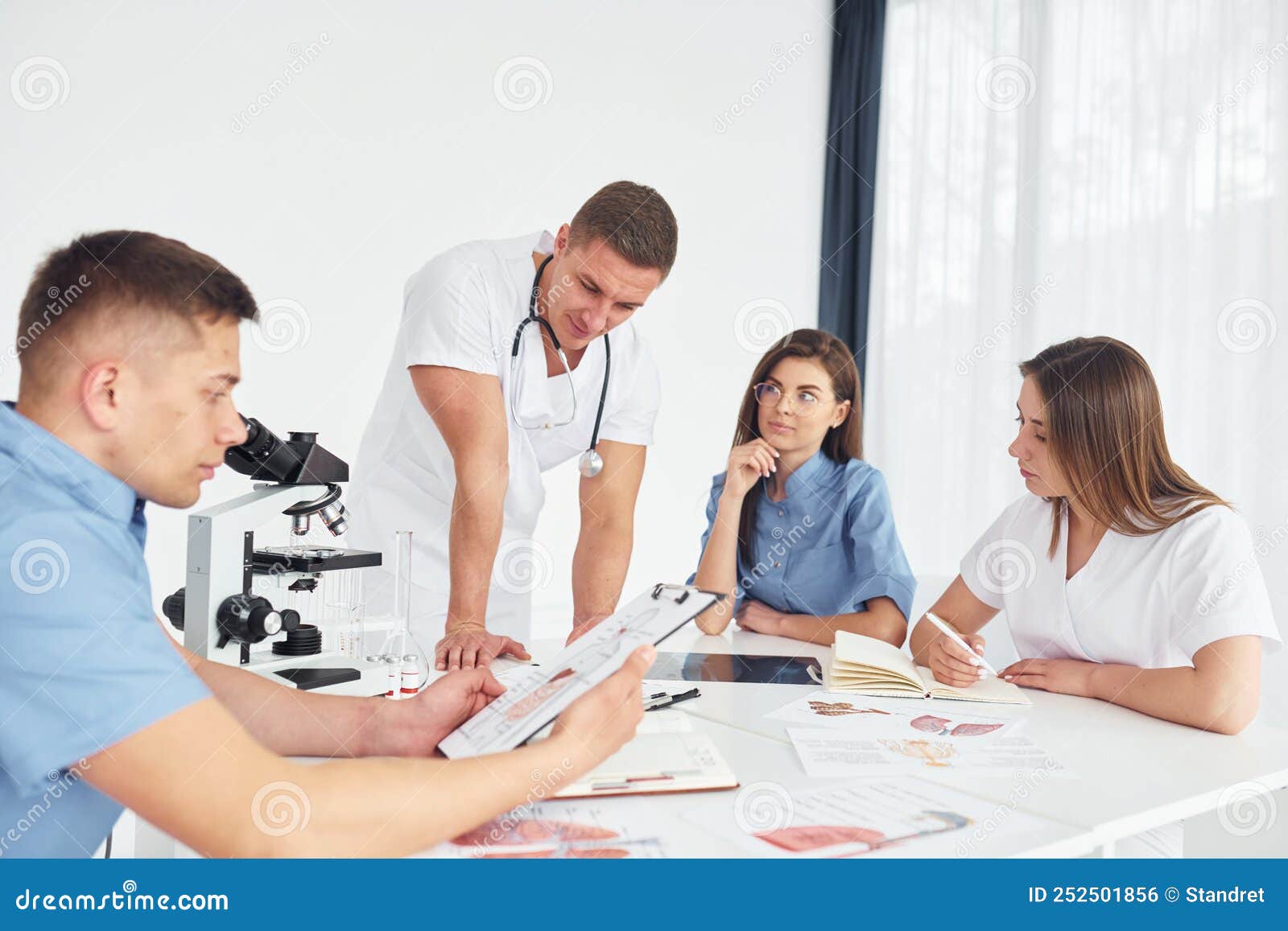 Sitting by the Table. Group of Young Doctors is Working Together in the ...