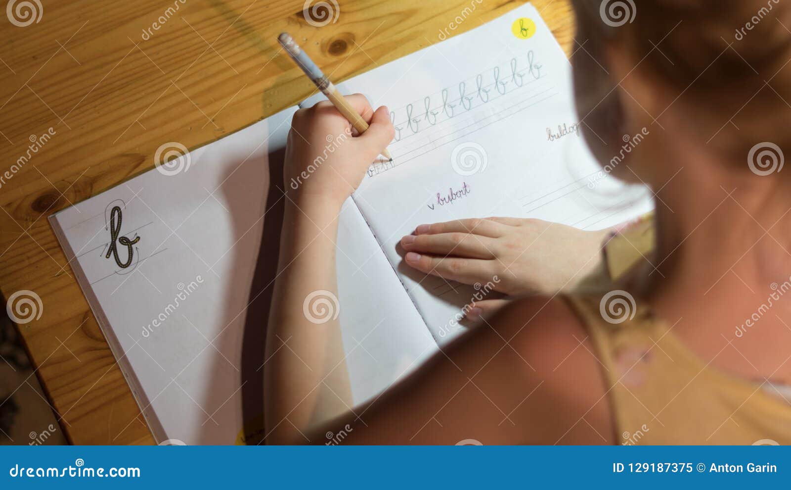 A Six Year Old Girl is Practicing Writing in a Notebook. Stock Image ...