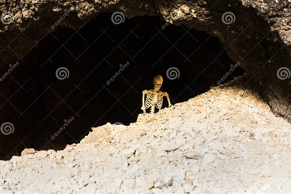 Skeleton in a Dark Cave in the Ground Crawling on Rocks Stock Image ...