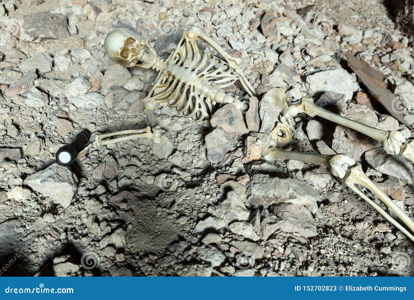 Skeleton in a Dark Cave in the Ground Lying on Rocks Stock Image ...