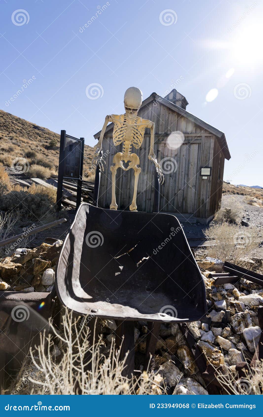 Skeleton Pushing a Rusty Old Wheelbarrow Near a Mining Shack in a Ghost ...