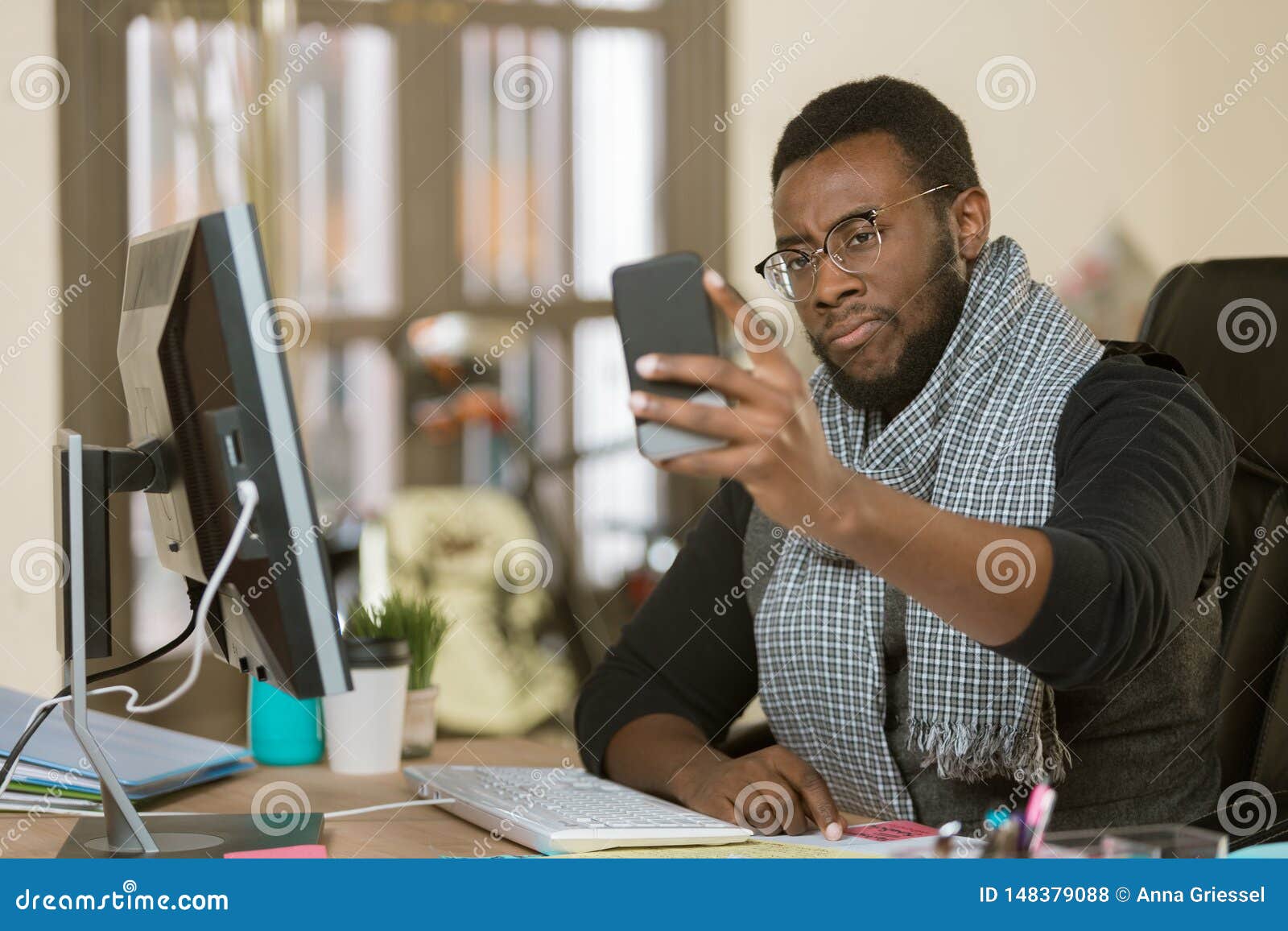 Skeptical Man in an Office Using Mobile Device Stock Photo - Image of ...