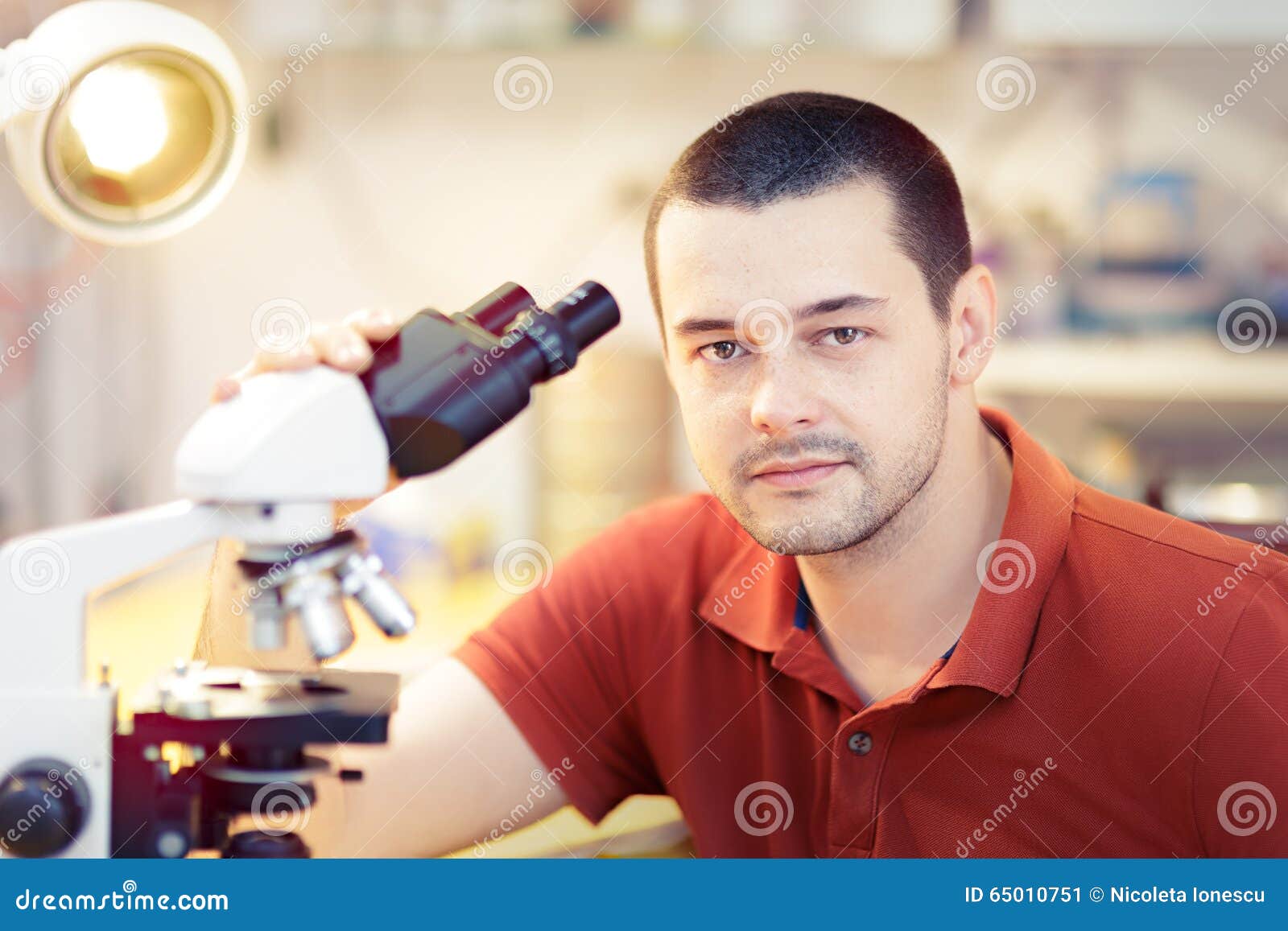 Skeptical Young Male Researcher with Microscope Stock Image - Image of ...