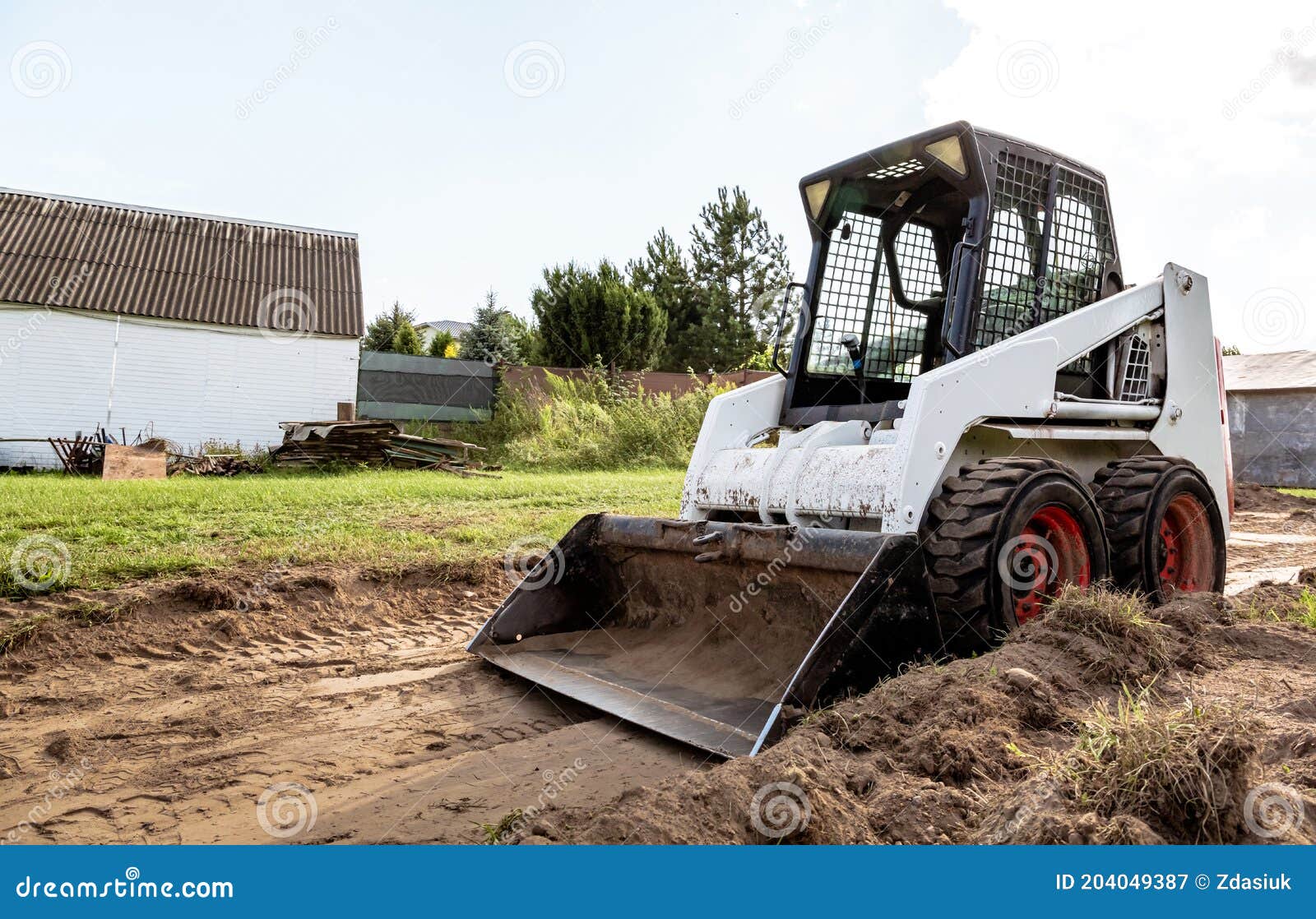 A Skid Steer Loader Clears the Site for Construction. Land Work by the ...