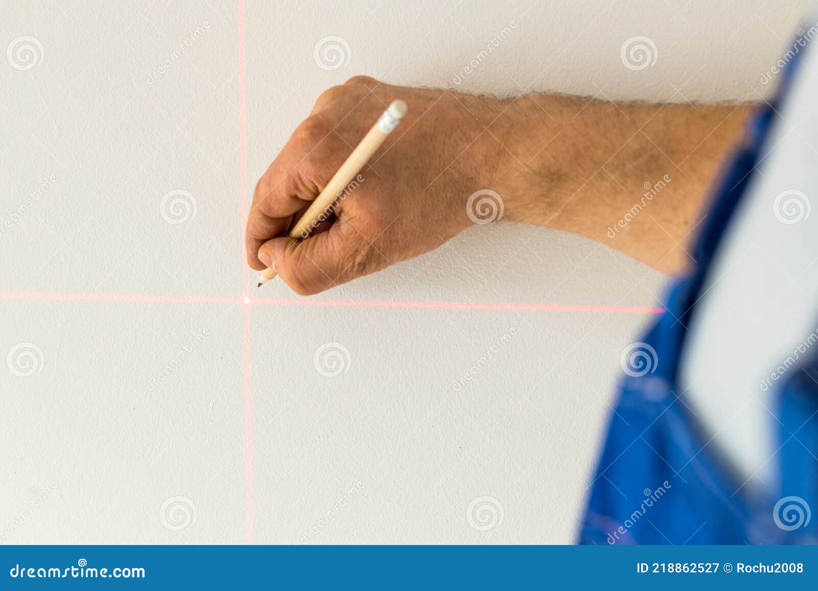 A Skilled Person Marks a Point on the Wall Marked with an Electronic ...