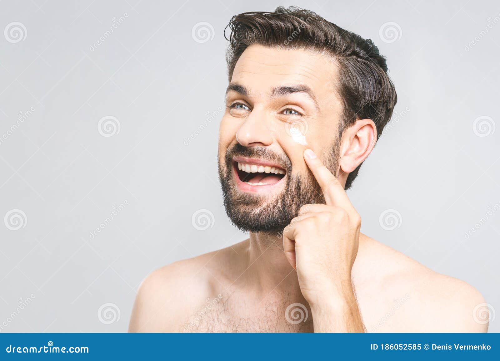 Skin Care Handsome Happy Young Shirtless Man Applying Cream At His