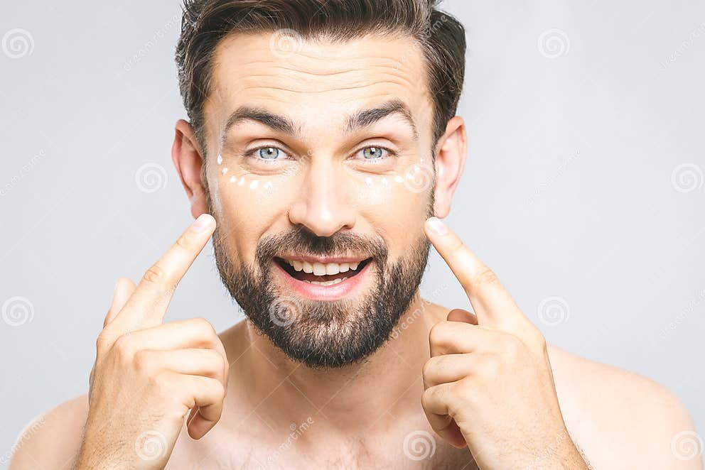 Skin Care Handsome Young Shirtless Man Applying Cream At His Face And