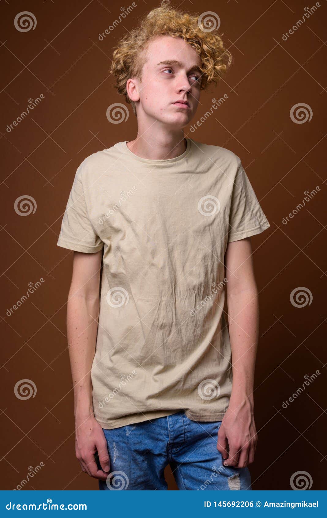 Skinny Young Man with Curly Hair Against Brown Background Stock Photo ... Skinny Young Man with Curly Hair Against Brown Background Stock Photo ...