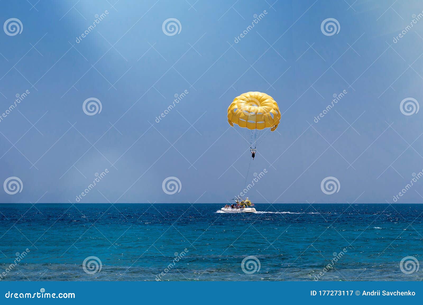 Skydiver Flying with a Yellow Parachute by Speed Boat on Sea. Skydiver ...