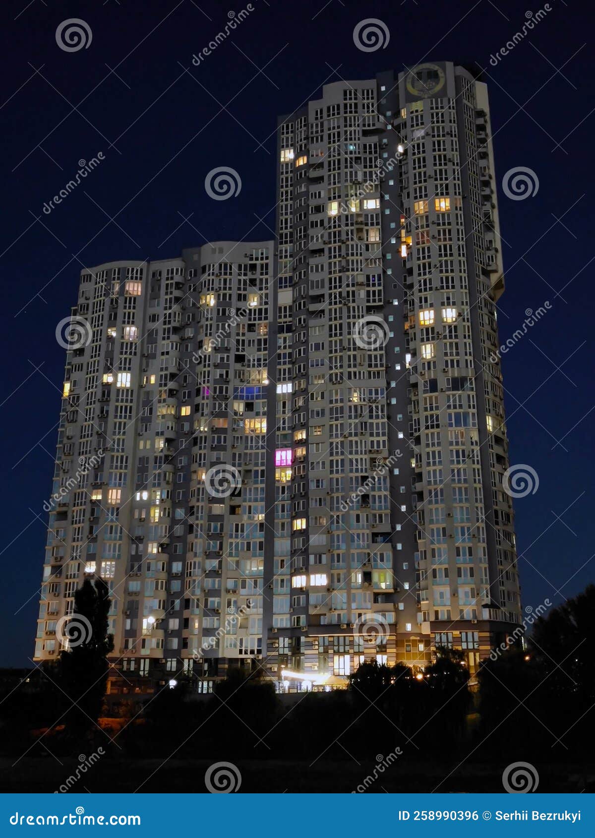 A Skyscraper with Many Illuminated Windows Against the Background of ...
