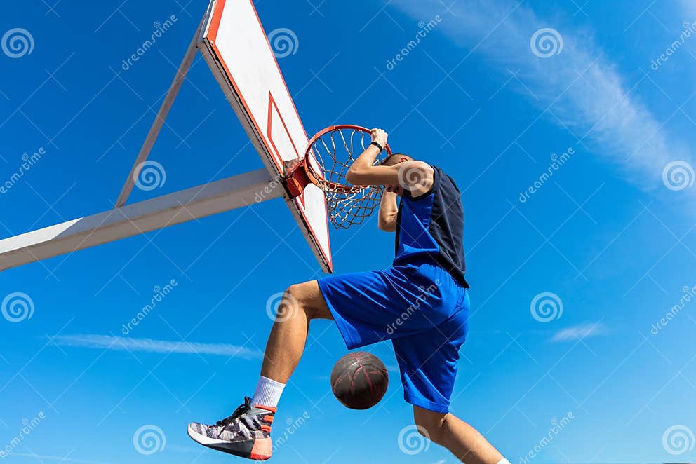 Slam Dunk. Side View of Young Basketball Player Making Slam Dunk Stock ...