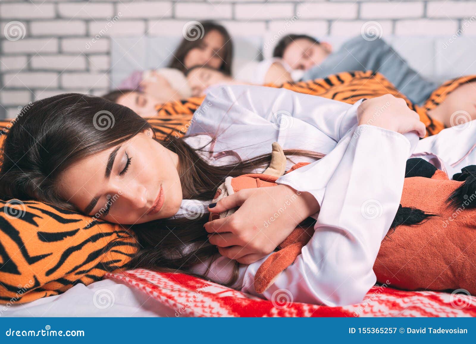 Sleeping Group of Young People on the Bed. Stock Image - Image of ...