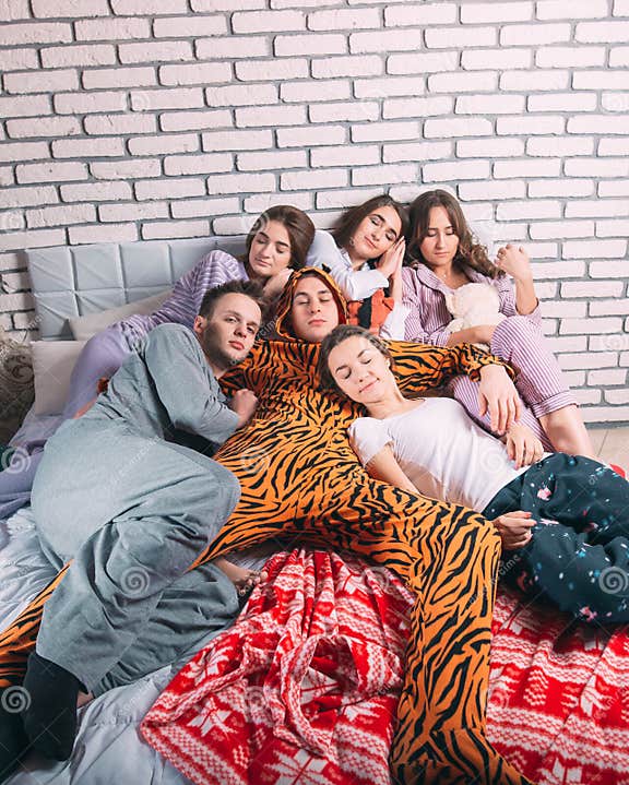 Sleeping Group of Young People on the Bed. Stock Image - Image of ...