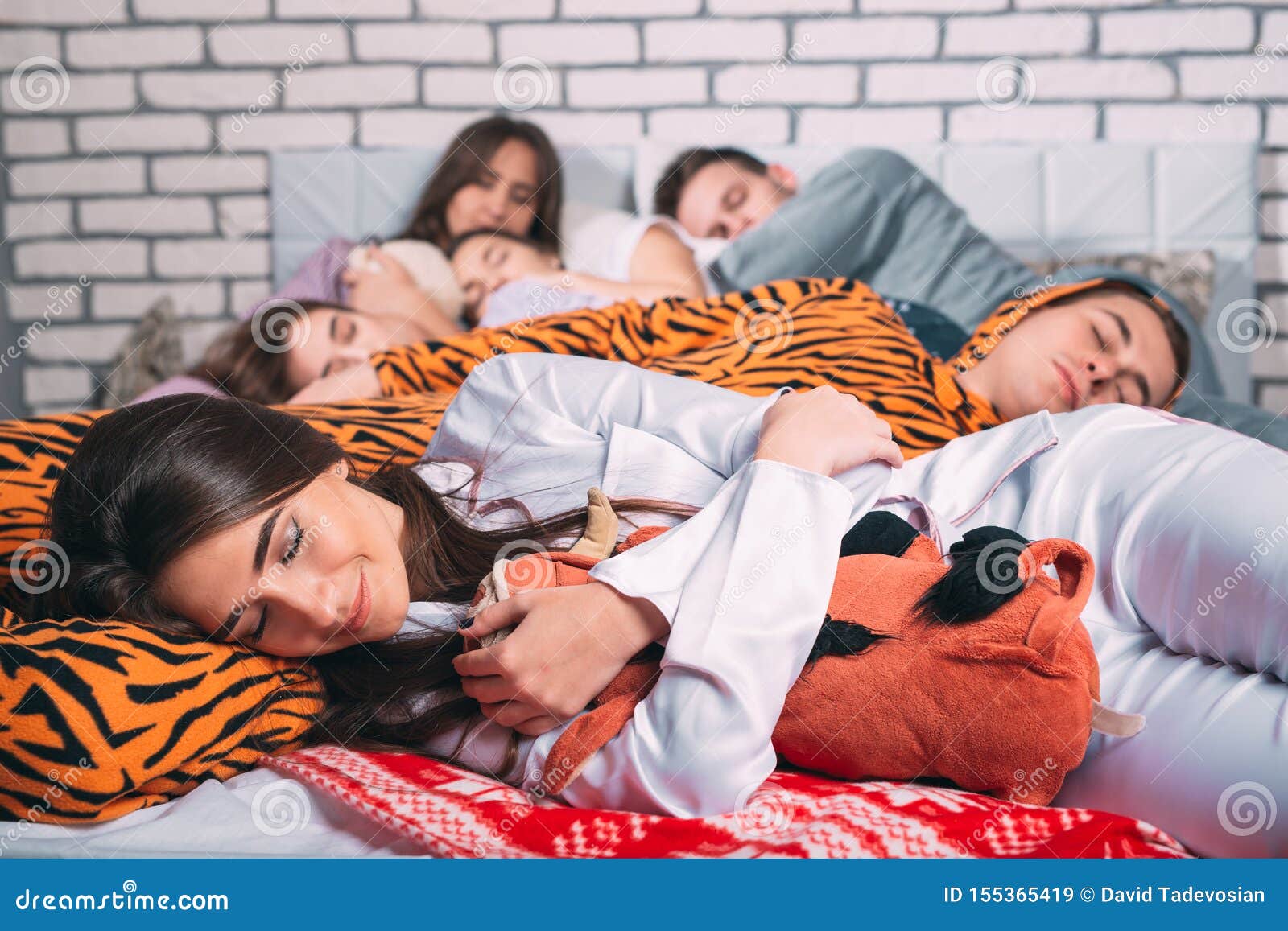Sleeping Group of Young People on the Bed. Stock Image - Image of ...