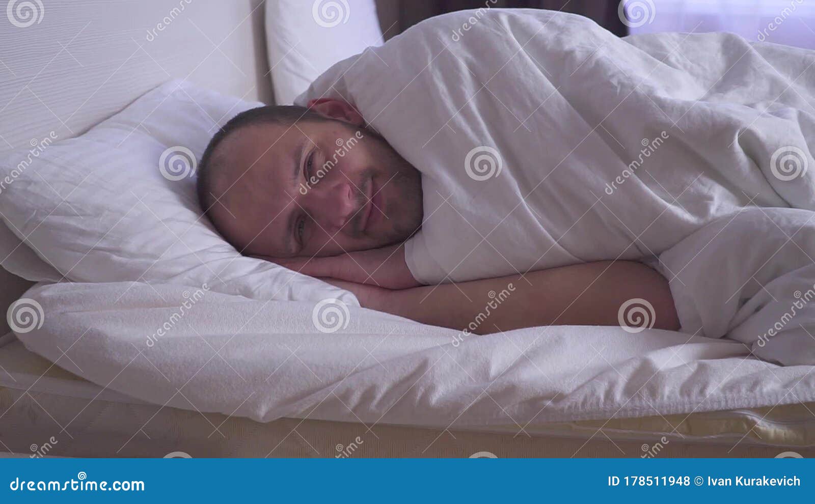 Sleeping Man Wakes Up in a Double Bed. Side View, Medium Shot. Stock ...